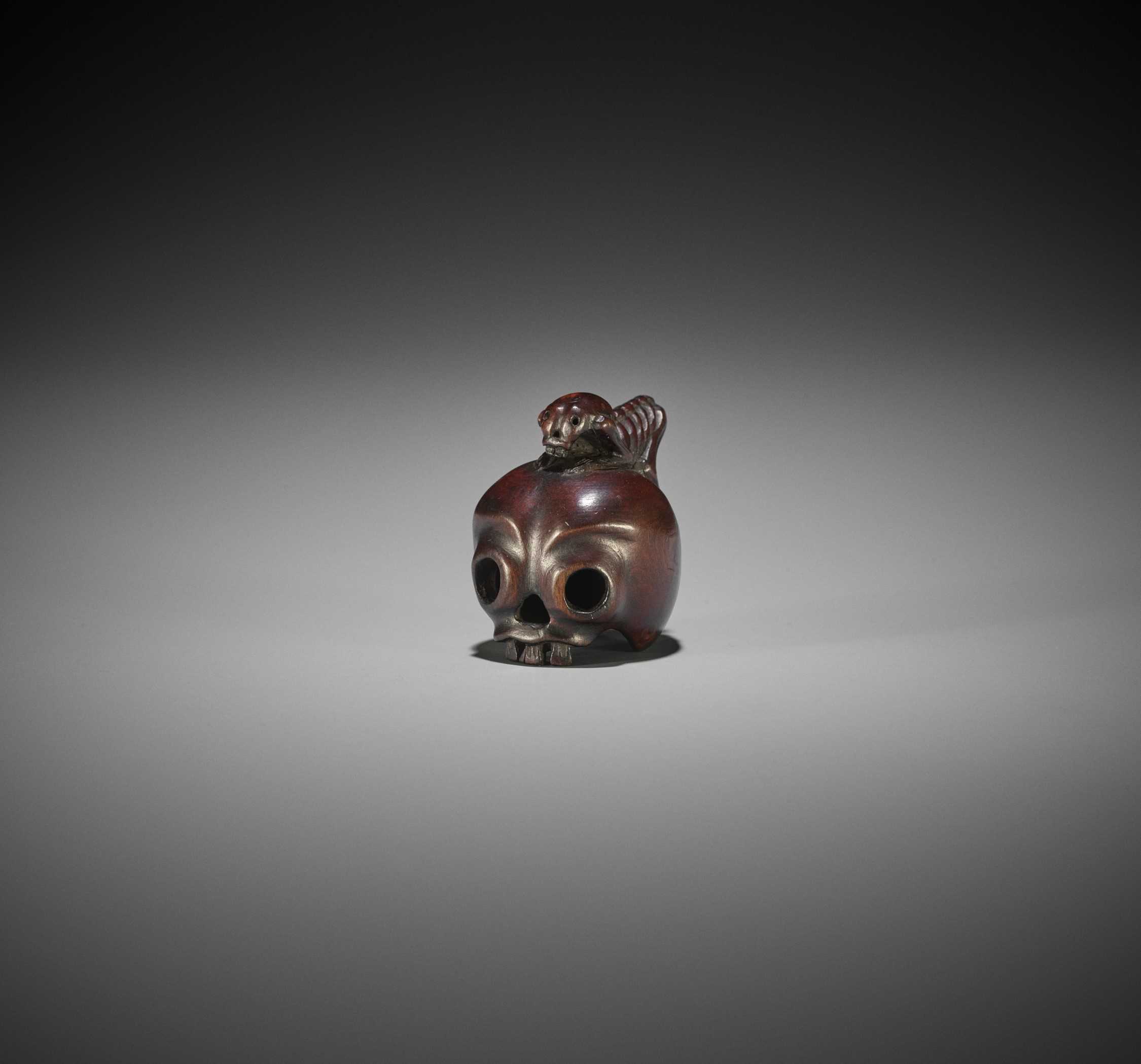 Lot 219 - A WOOD NETSUKE OF A SKELETON ON A GIANT